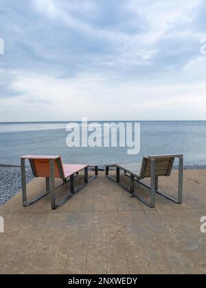 Benches for lying by the sea. Sun loungers in the park against the ...