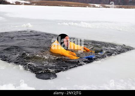 A firefighter wearing a cold-water immersion protective suit acts as a ...