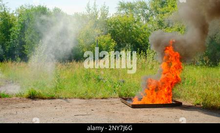Flames flare up on a road as thick smoke reduces visibility during ...