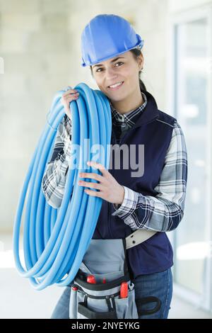 woman engineer holding pipes is smiling at camera Stock Photo - Alamy