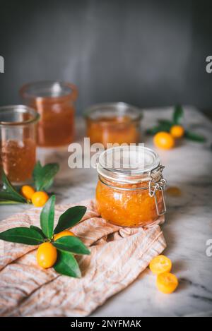 Jar of tasty kumquat jam and fresh fruits on blue background Stock ...