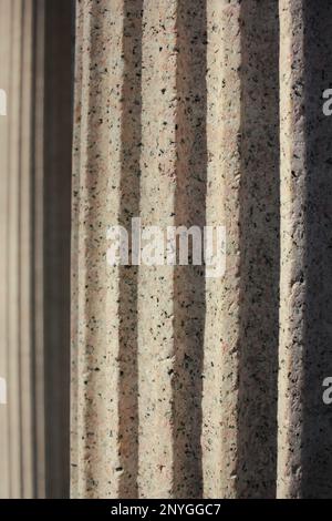 A closeup view of a fluted column carved in natural stone in a black ...