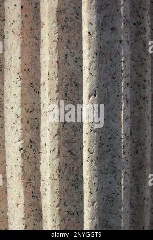 A closeup view of a fluted column carved in natural stone in a black ...