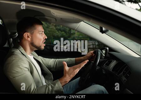 Stressed businessman in driver's seat of modern car Stock Photo - Alamy