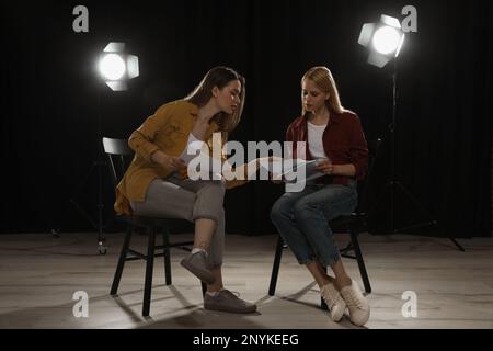 Professional actresses reading their scripts during rehearsal in ...