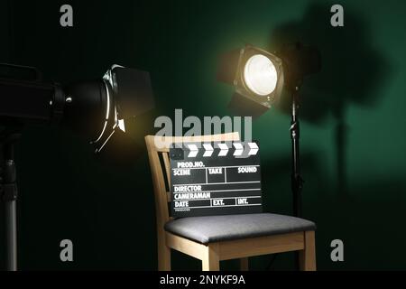 Chair with clapperboard under spotlight in studio Stock Photo - Alamy