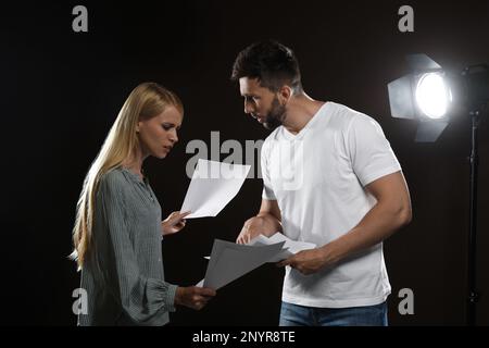 Professional actors reading their scripts during rehearsal in theatre ...