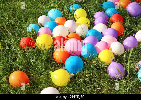 Lots of colorful water bombs on green grass outdoors Stock Photo - Alamy