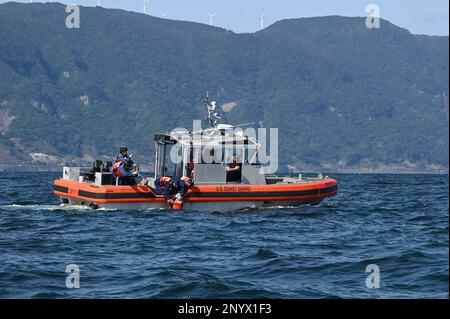 Crewmembers aboard a Long-Range Interceptor (LRI) cutter boat approach ...