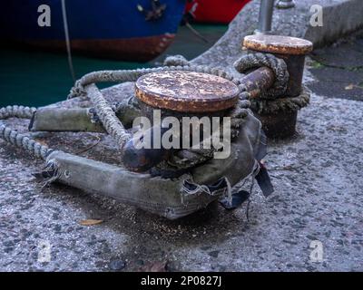 rope goes into the water from the bollard. Attaching boats to the pier ...