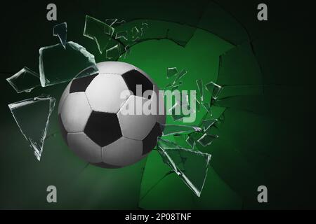 Soccer ball breaking up glass against black background Stock Photo - Alamy