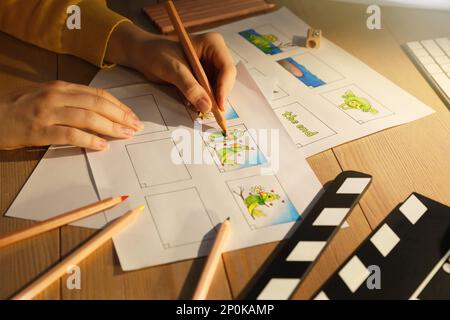 Woman drawing cartoon sketches at workplace, closeup. Pre-production ...