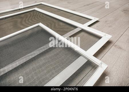 Set of window screens on wooden floor, closeup Stock Photo - Alamy
