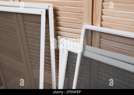 Set of window screens near wooden folding screen, closeup Stock Photo ...