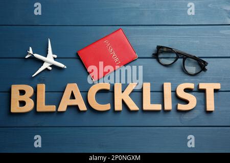 Word Blacklist of letters, toy airplane and passport on grey wooden ...