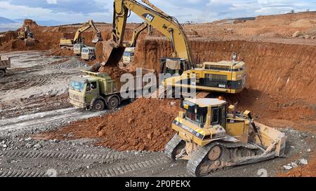 Excavators are loading continuously the trucks, working at a huge ...