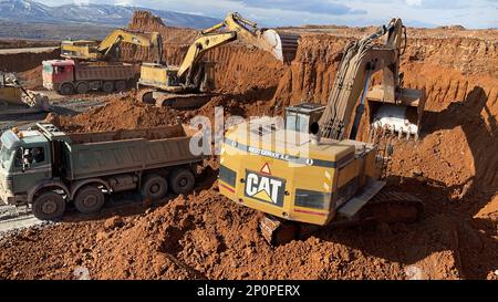 Excavators are loading continuously the trucks, working at a huge ...