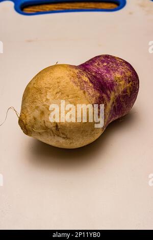 A common turnip with an odd shape on a kitchen cutting board Stock ...