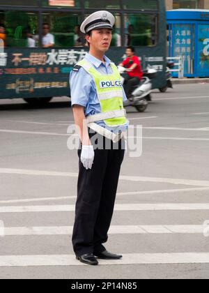 Police traffic officer policeman at a busy road junction in the Chinese ...