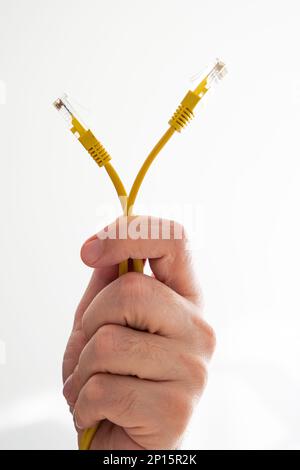 Close-up Hand holding ethernet cable on network switches background ...
