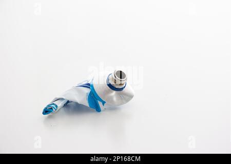 Used up squeezed out metal paste tube ready for recycling close up ...