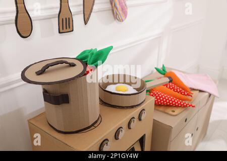 Toy cardboard kitchen with stove and utensils at home Stock Photo - Alamy