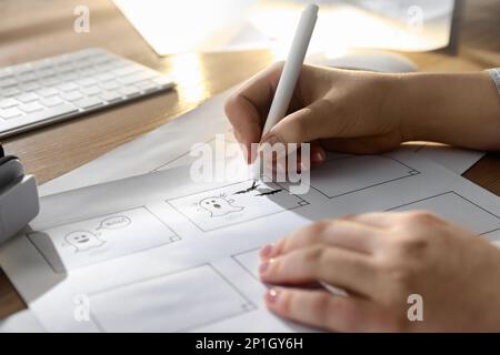 Woman drawing cartoon sketches at workplace, closeup. Pre-production ...