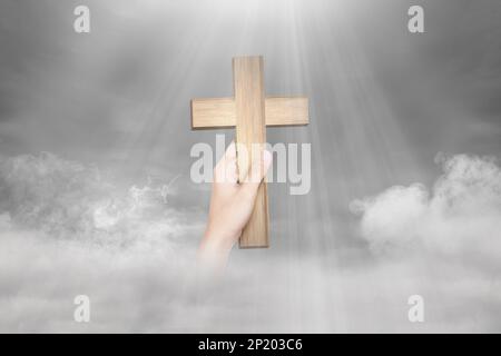 Human hand holding Christian cross with sunset sky background Stock ...
