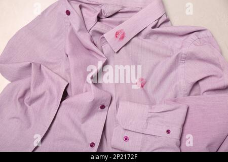 Men's shirt with lipstick kiss marks on light background, top view ...