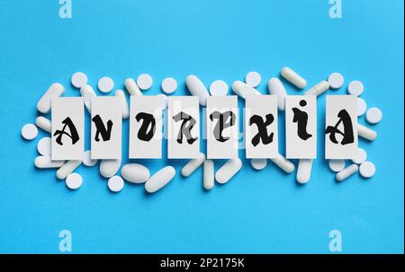 Word Anorexia made of paper pieces with letters on light blue ...