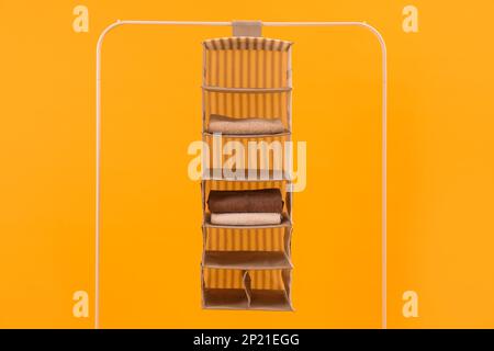 Foldable organizer on rack against yellow background Stock Photo - Alamy