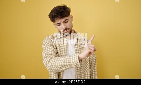 Arab man standing over yellow background covering eyes with hands ...