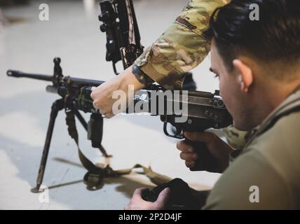A paratrooper with the 173rd Airborne Brigade disassembles an M240B ...