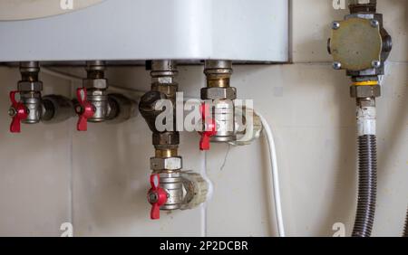 Hidden water taps for connecting a gas boiler on a tiled wall. Plumbing ...