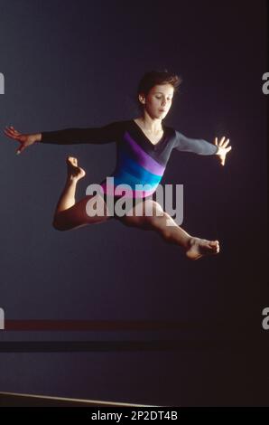 Young girl gymnast flying through the air. Taking a leap Stock Photo ...