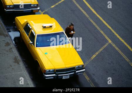 Taxi driver having lunch and eating sandwich while waiting in his car ...