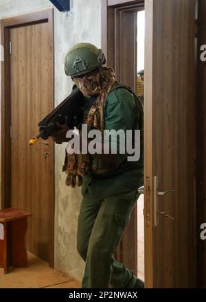 An Ivorian Special Forces Soldier keeps his weapon at a high ready ...
