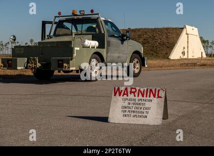 An explosive warning sign sits outside of an igloo during a munitions ...