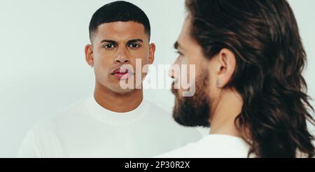 Two young men with radiant and flawless skin standing side by side in a ...