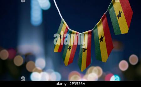 A garland of Ghana national flags on an abstract blurred background ...