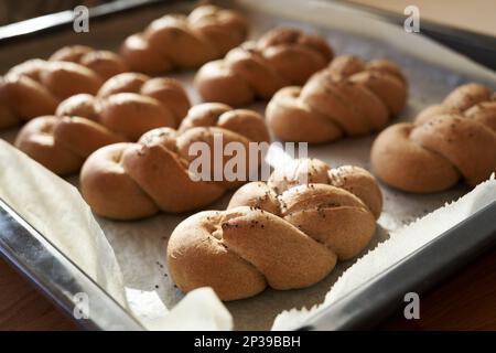 Homemade braided bread rolls or buns baked from whole grain spelt flour ...
