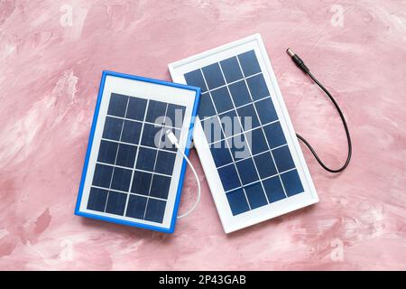 Portable solar panels with cables on pink grunge background Stock Photo ...