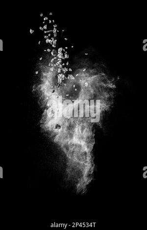 Split debris of stone exploding with white powder against black ...