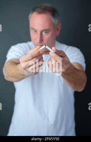 handsome man quitting smoking breaking his last cigarette Stock Photo ...