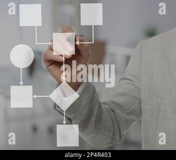 Man pointing at flowchart on virtual screen against black background ...