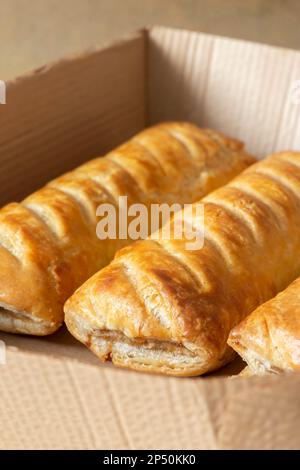Sausage rolls in a cardboard takeaway tray. Sustainable biodegradable ...