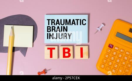 TBI traumatic brain injury symbol. Concept words TBI traumatic brain injury on paper on a ...