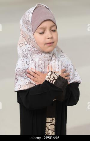 Young Muslim Girl Making Traditional Prayer To God While Wearing A ...