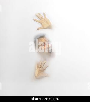 Screaming male face with hands pressed against window from a foggy ...