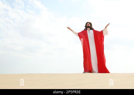 Jesus Christ raising hands in desert. Space for text Stock Photo - Alamy